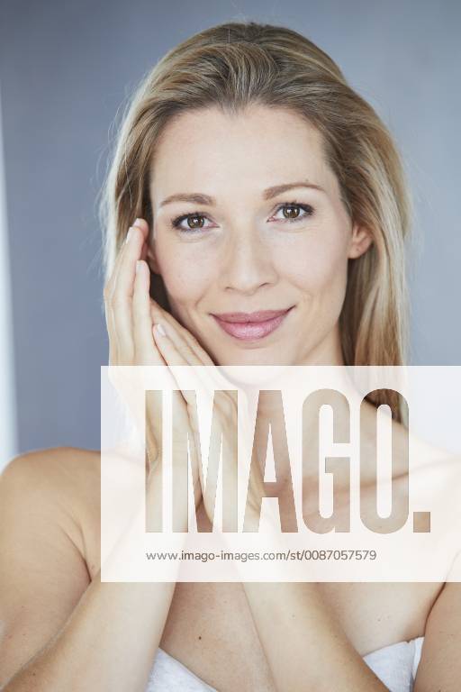 Portrait Of Smiling Blond Woman Wrapped In Towel Model Released