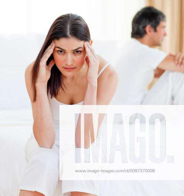 Sad Couple Sitting Sitting Separately On Their Bed After Having A Row