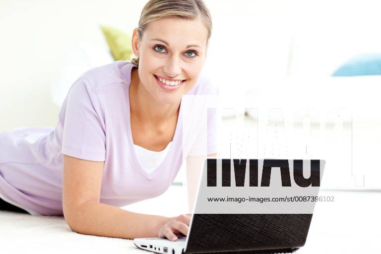 Positive Woman Using Her Laptop On The Floor In The Living Room Model