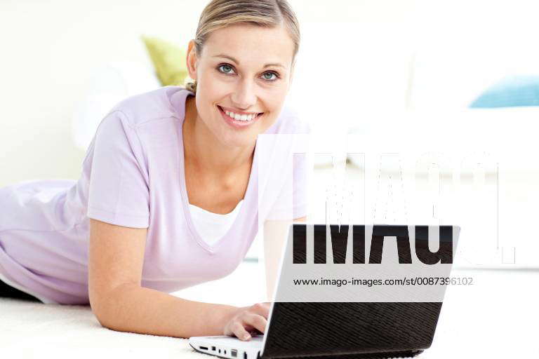 Positive Woman Using Her Laptop On The Floor In The Living Room Model