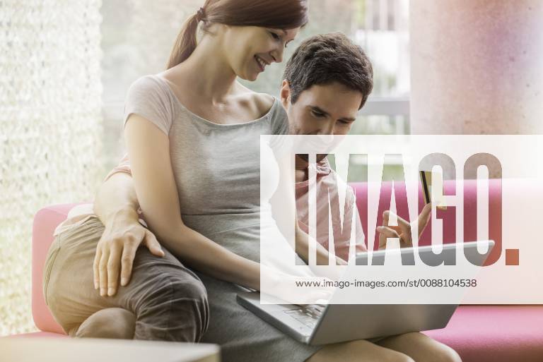 Couple shopping online from home computer