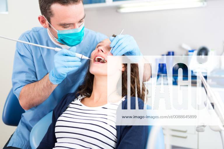 Young attractive woman being cured by a dentist model released Symbolfoto