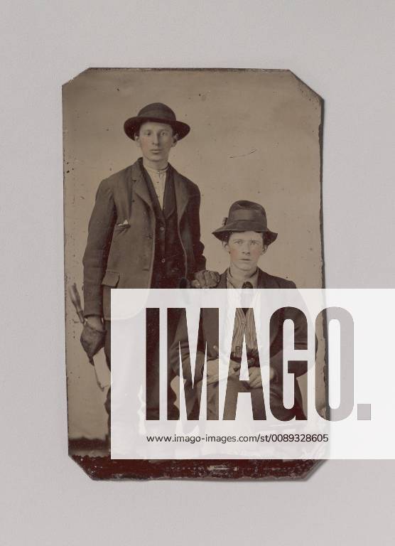 Two Young Men, One Seated and One Standing, Holding Carpentry Tools ...