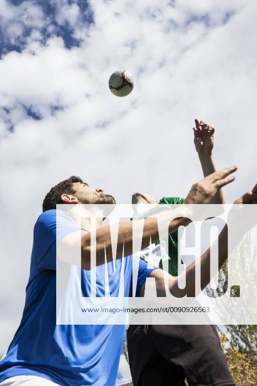 Football players jumping to head the ball during a football match model ...