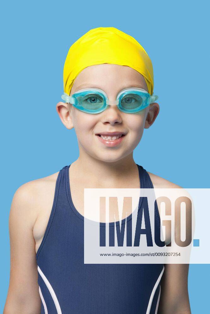 Portrait of a happy young girl wearing swim goggles over blue ...