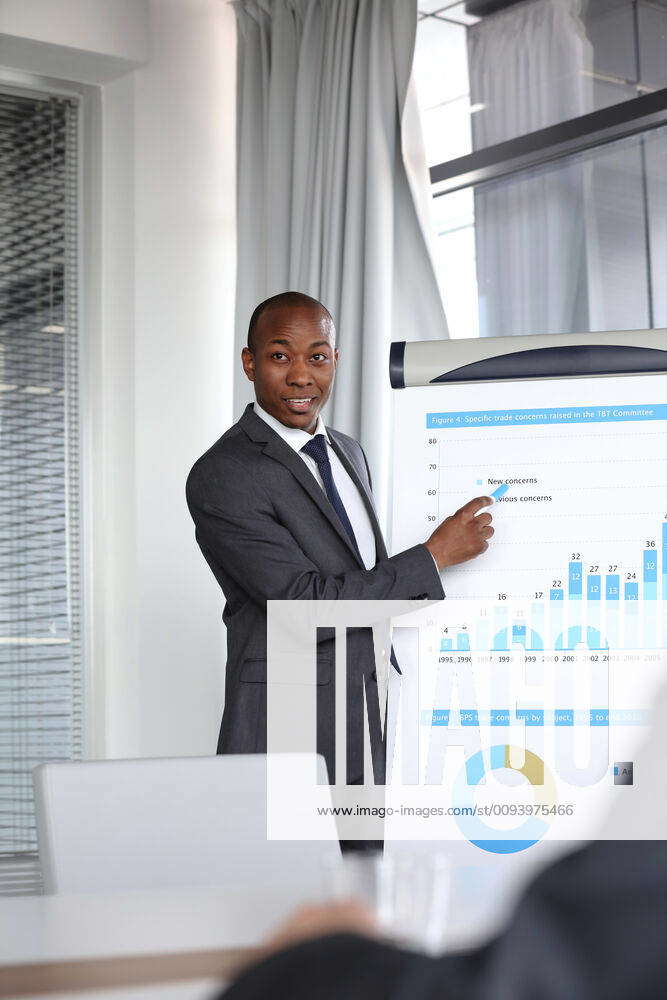 Young businessman explaining graph while giving presentation in board ...