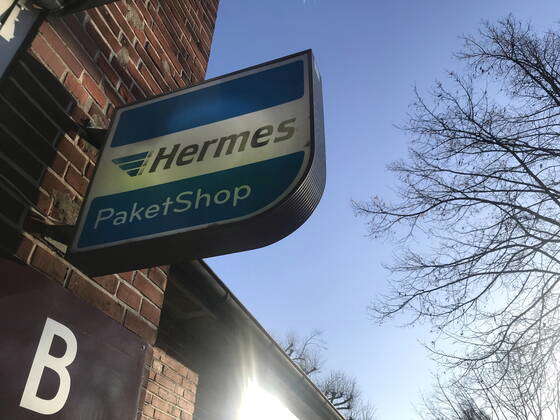 Logo of the parcel service Hermes in front of a shop