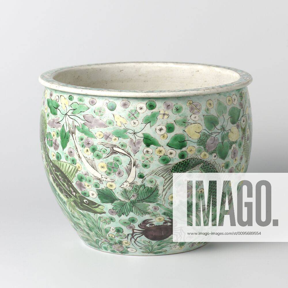 Ovoid fish bowl with a crab, shrimp and fish among water plants ...