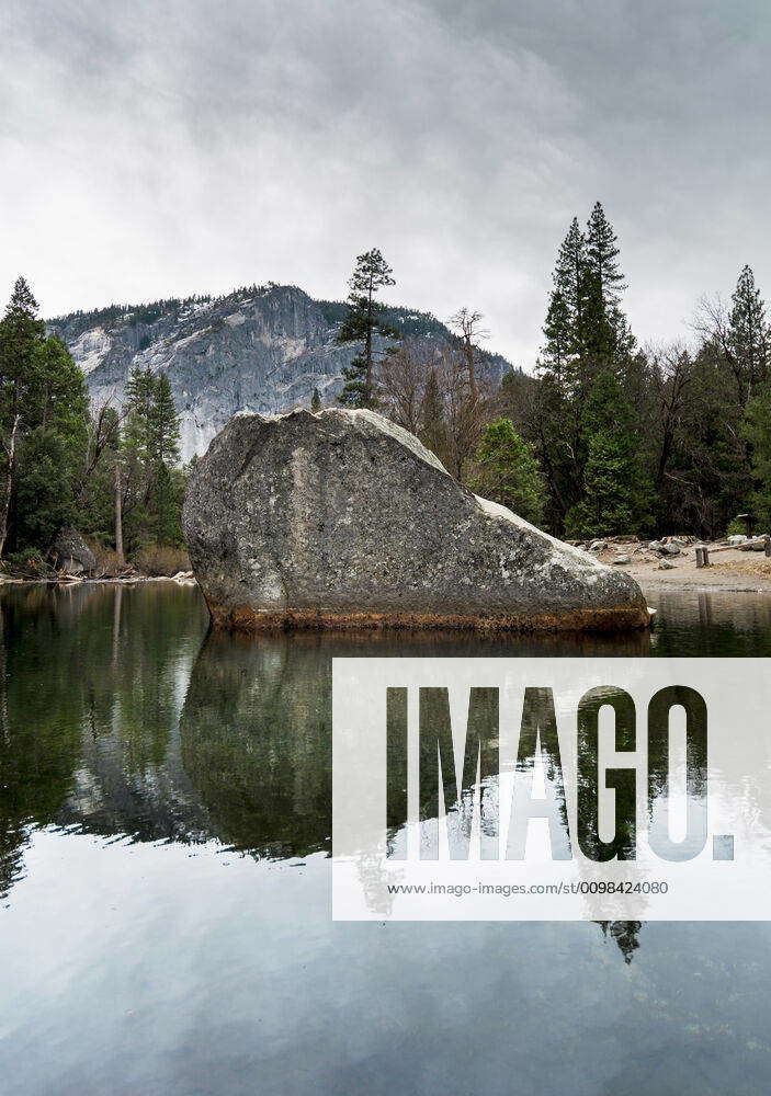 A big boulder at one of the Lakes of the Yosemite Park being reflected ...