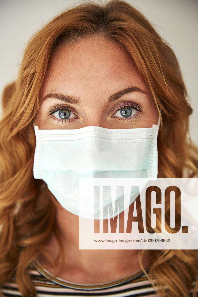 Portrait of red-haired woman wearing a face mask at home model released ...