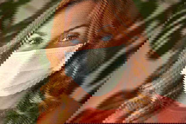 Portrait of red-haired woman wearing a face mask at home model released ...