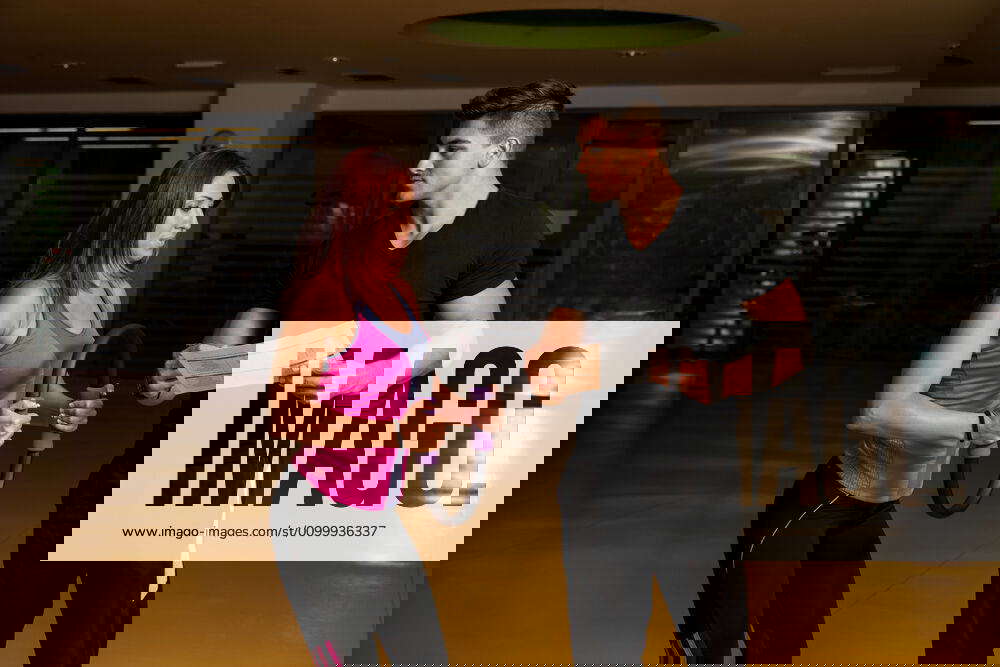 Woman looking at exercise charts with personal trainer Woman looking at ...