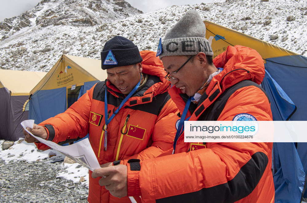 LHASA, Xue Qiangqiang and his teammate view a map at the base camp of ...