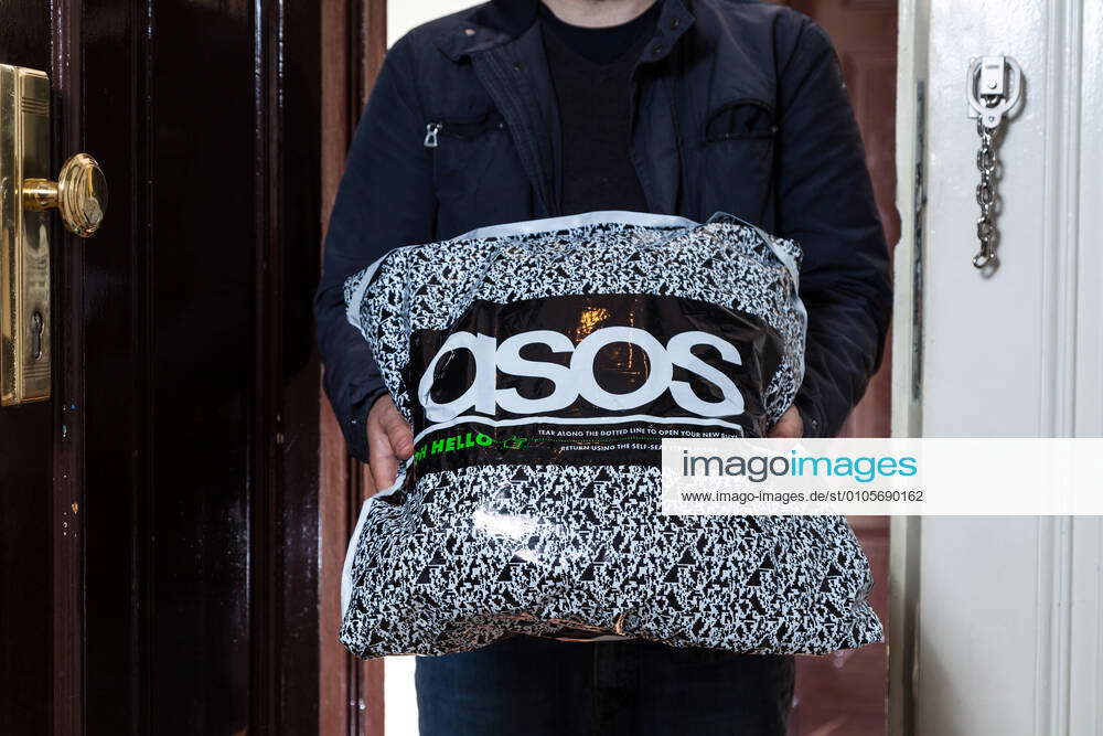 Parcel carrier delivers an Asos parcel to the front