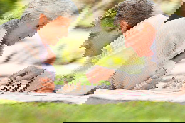 Elderly couple playing chess Elderly couple playing chess in a park ...