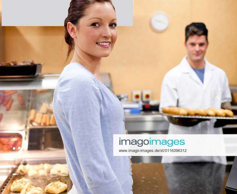 Portrait of a customer in the queue waiting for baguette and bread in a ...