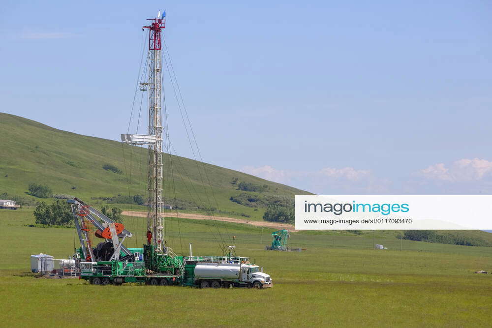 Triple rig drilling equipment and a fuel tank truck at the site of an ...