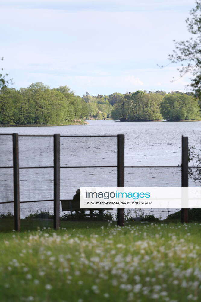 Two people sitting on a bench at the Wall memorial at Groß Glienicker ...