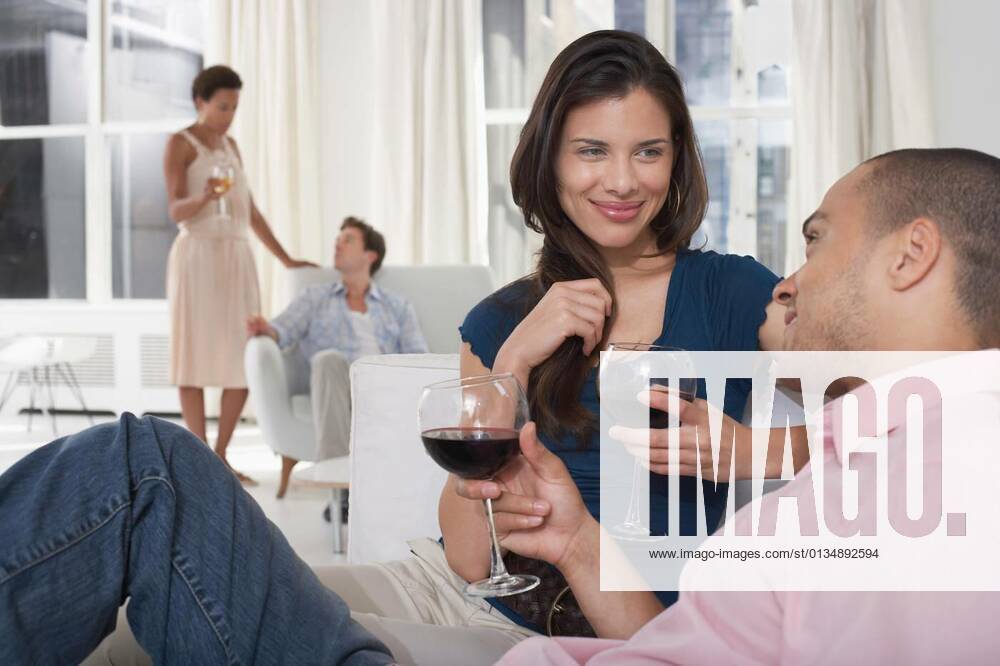 Young Couples Drinking Wine In Living Room Model Released Symbolfoto