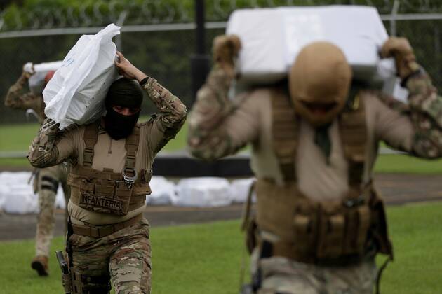Agents of the National Aeronaval Service of Panama carry the packages ...