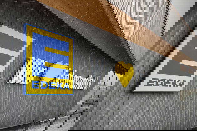 EDEKA company logo with the slogan WIR LEBEN LEBENSMITTEL at a store ...