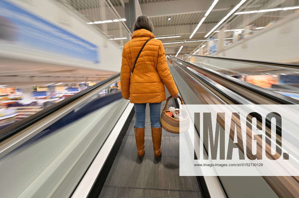 Hectic shopping A woman with shopping basket on the conveyor belt in ...