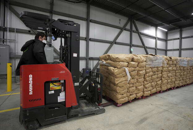 TORONTO, ON, CANADA: A forklift driver loads PEI potatoes to be shipped ...