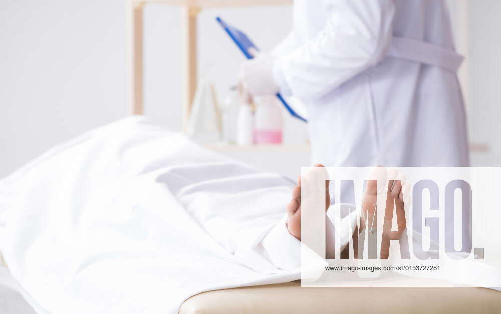 Police coroner examining dead body corpse in morgue, model released ...