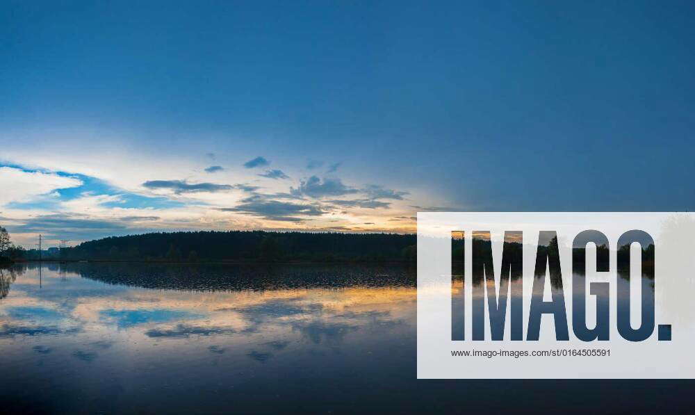 Panoramic landscape view of a big blue river at sunset near the forest ...