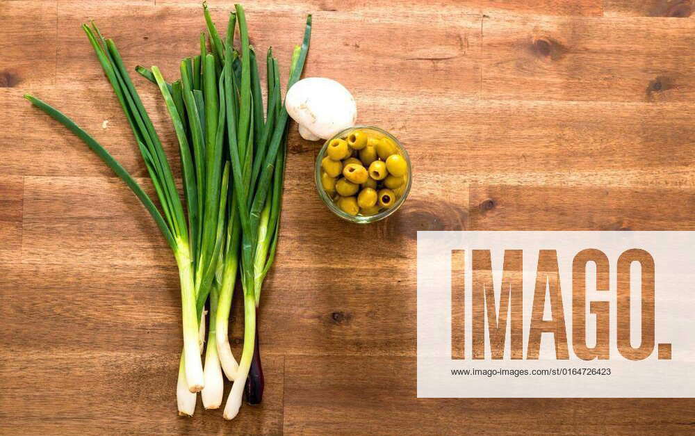 Spring onions and Olives., Organic leek on a wooden kitchen Table