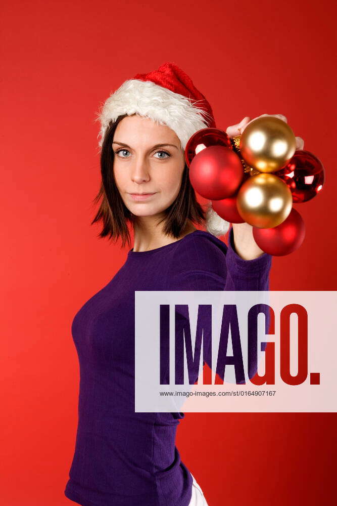 A Young Female Holding Up Christmas Decorations