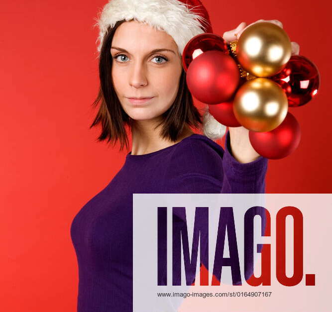 A Young Female Holding Up Christmas Decorations