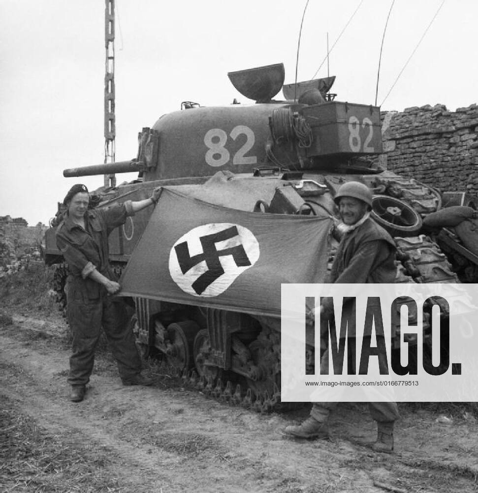 A Sherman tank crew from 27th Armoured Brigade with a German swastika ...
