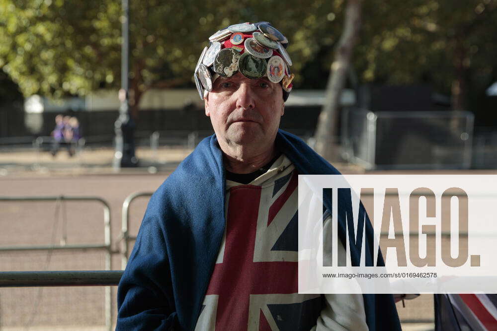 LONDON, UNITED KINGDOM: A man wear a hat with Queen Elizabeth button ...