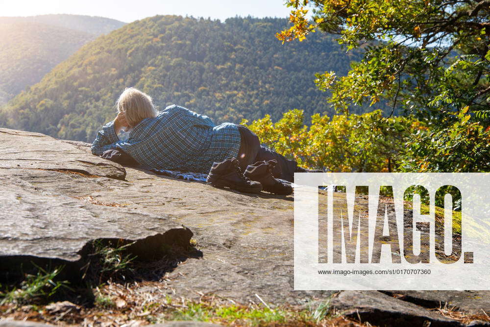 Golden October hiker sunbathing on a rock in the Palatinate Forest in ...