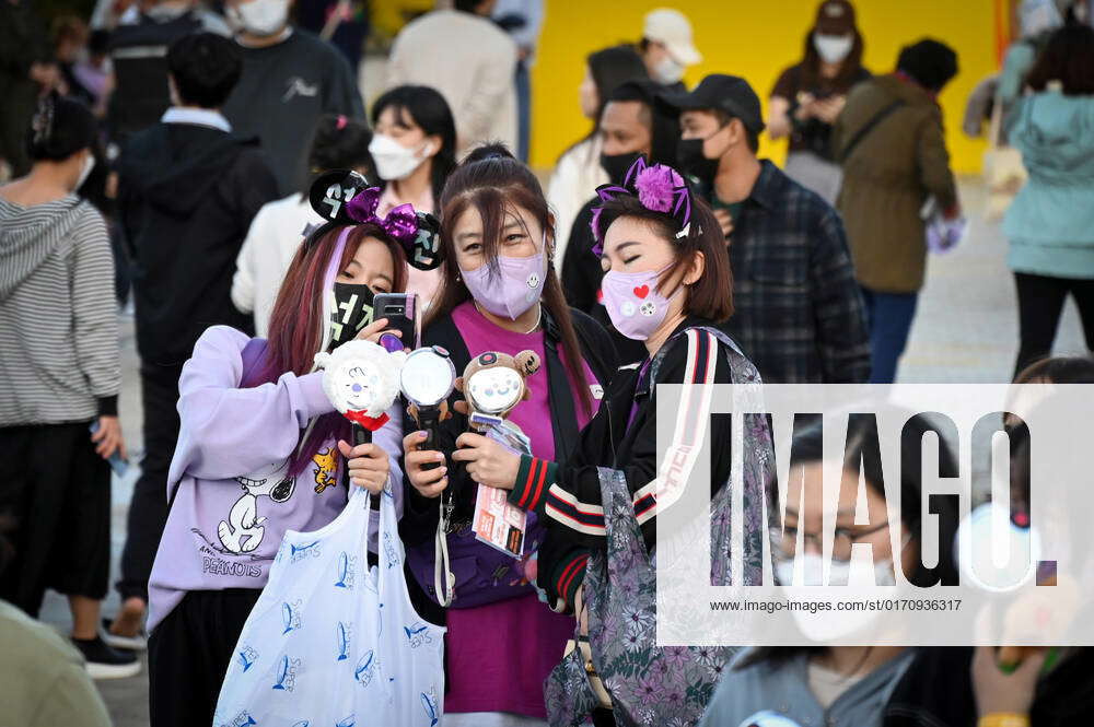 Fans take photos near the venue for a BTS concert at Busan Asiad Main ...