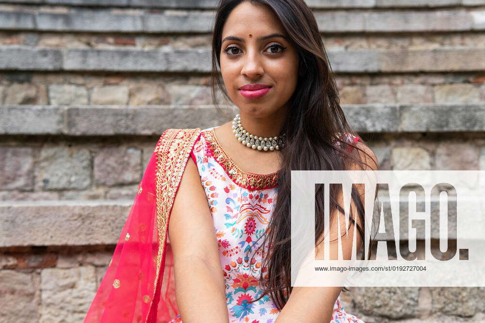 Side view of happy young Indian female in traditional sari outfit ...