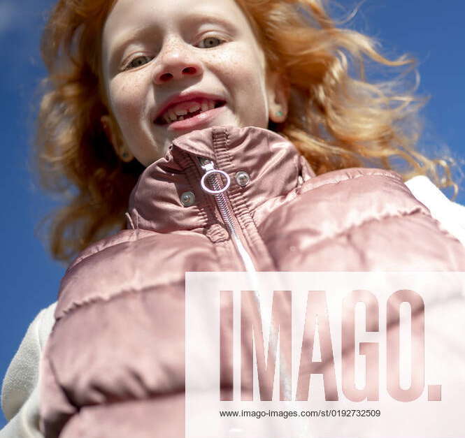 Smiling girl wearing padded jacket on sunny day model released, Symbolfoto