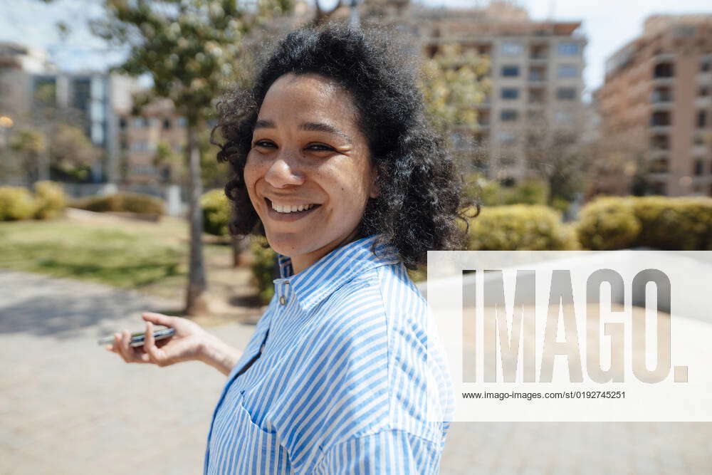 Happy woman looking over shoulder on sunny day model released, Symbolfoto