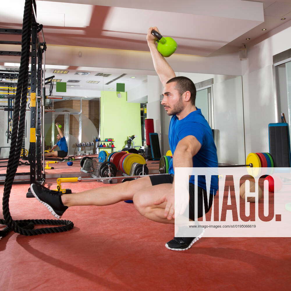 Crossfit fitness man balance Kettlebells with one leg exercise at gym ...