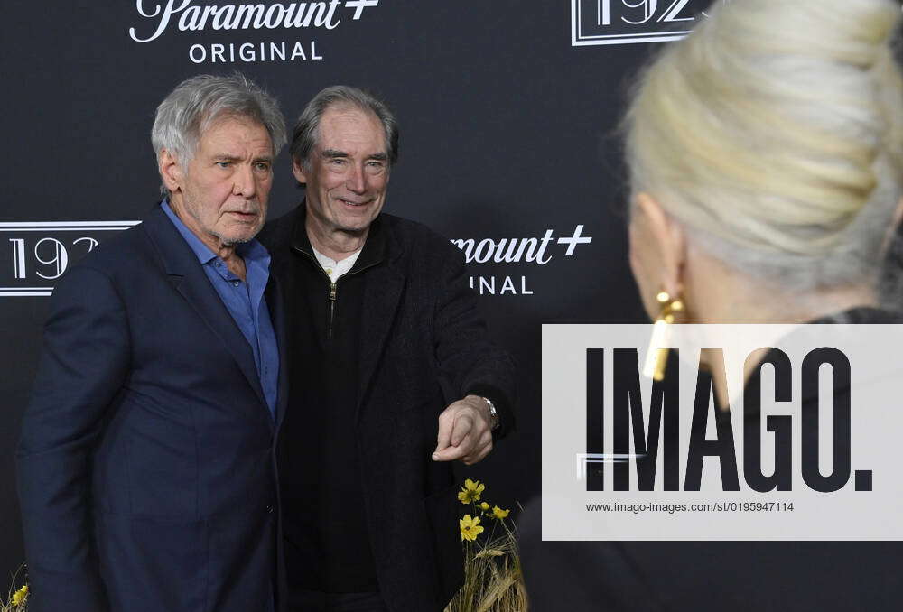 Cast members Harrison Ford (L) and Timothy Dalton greet Helen Mirren at the premiere of Paramount
