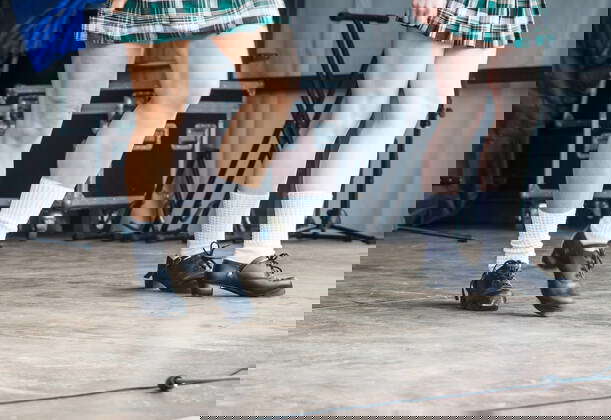 Female legs of two irish dancers in green checkered dresses on the ...