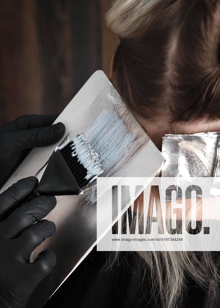 a Boy Woman in a Hairdressing salon colors itself the Hair blond ...