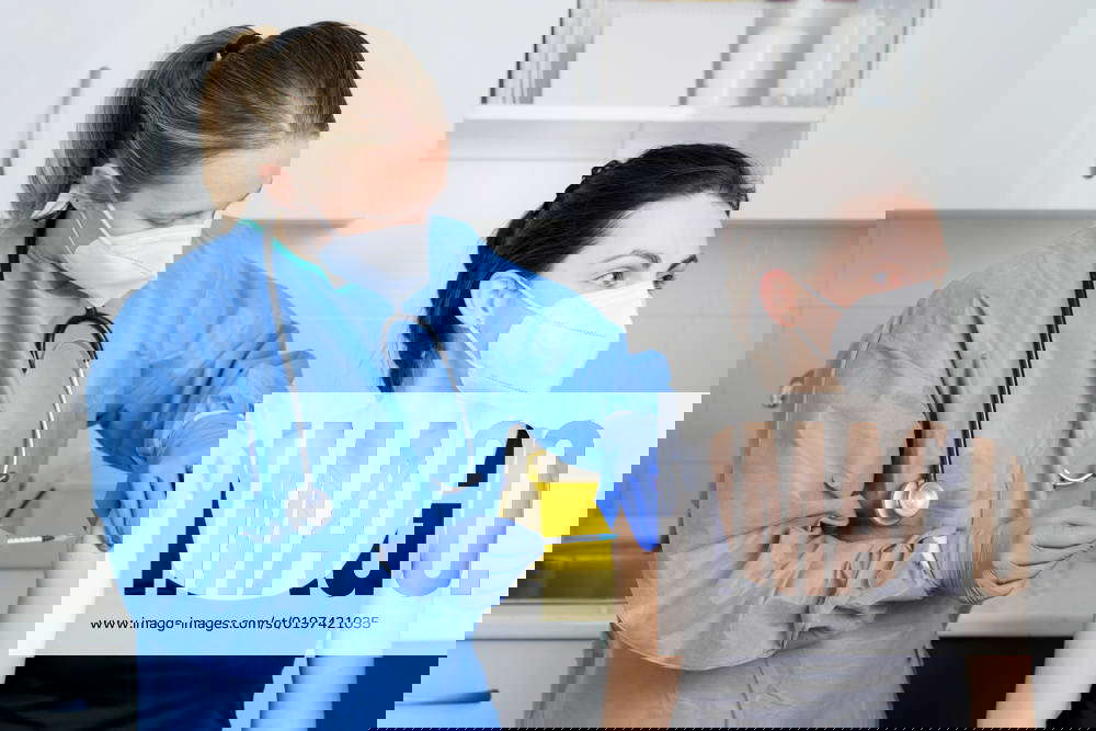 Close up of young woman with protective face mask getting vaccinated ...