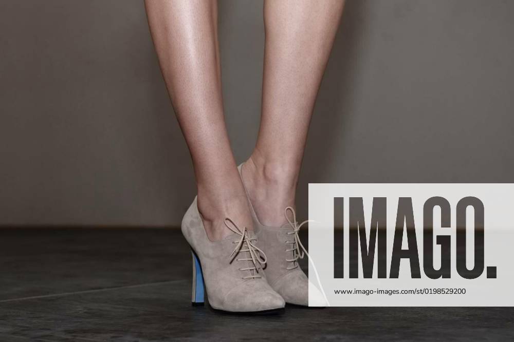 Bare female legs in suede boots with shoelaces, Cropped image of bare ...