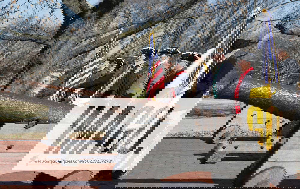 Civil War reenactors stand in front of Civil War canons near a statue ...