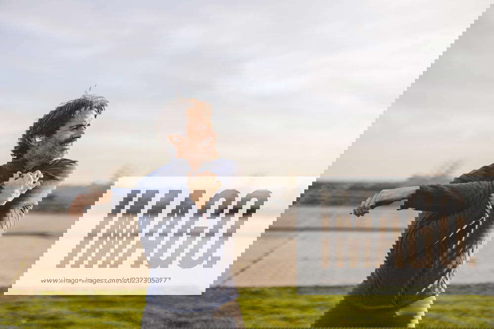 Mature man doing stretching exercise in park model released, Symbolfoto