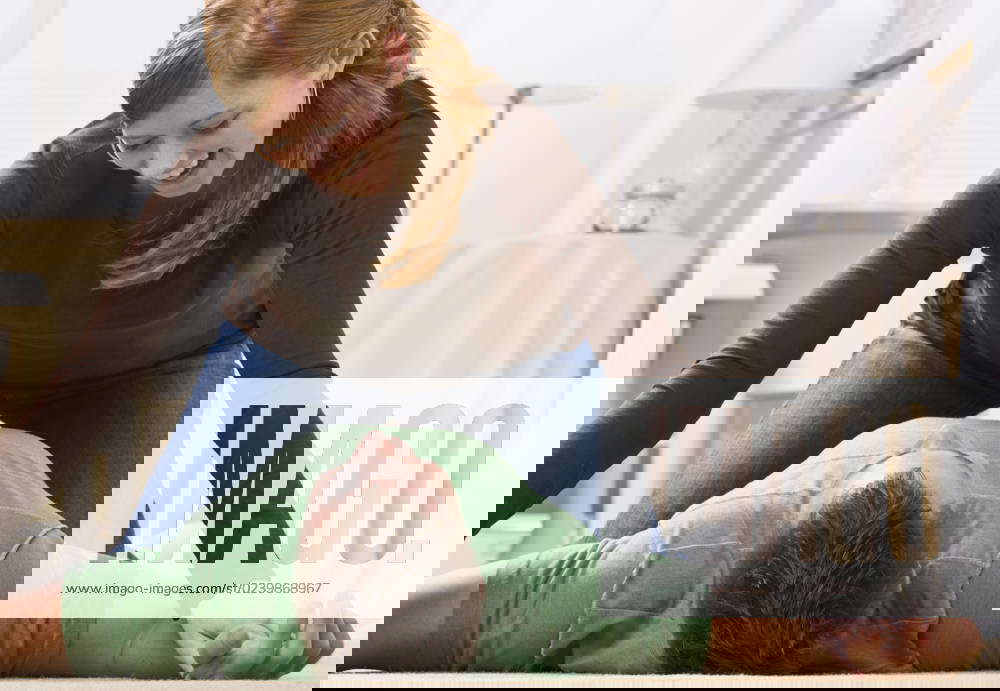 A cute and playful redhead pinning a man to the floor. She is smiling ...