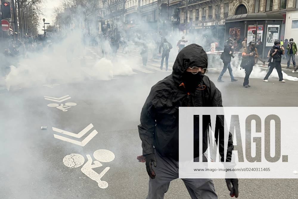France Protests 8397379 23.03.2023 A demonstrator walks amid fuming ...