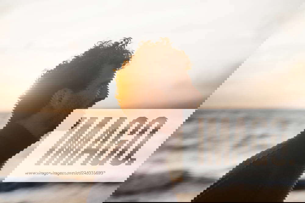 Back lit man in front of sea at sunset model released, Symbolfoto